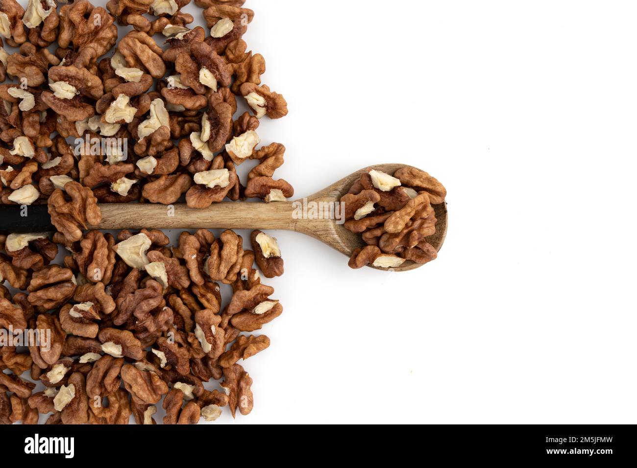 peeled halves of walnuts in spoon on heap isolated on white background ...
