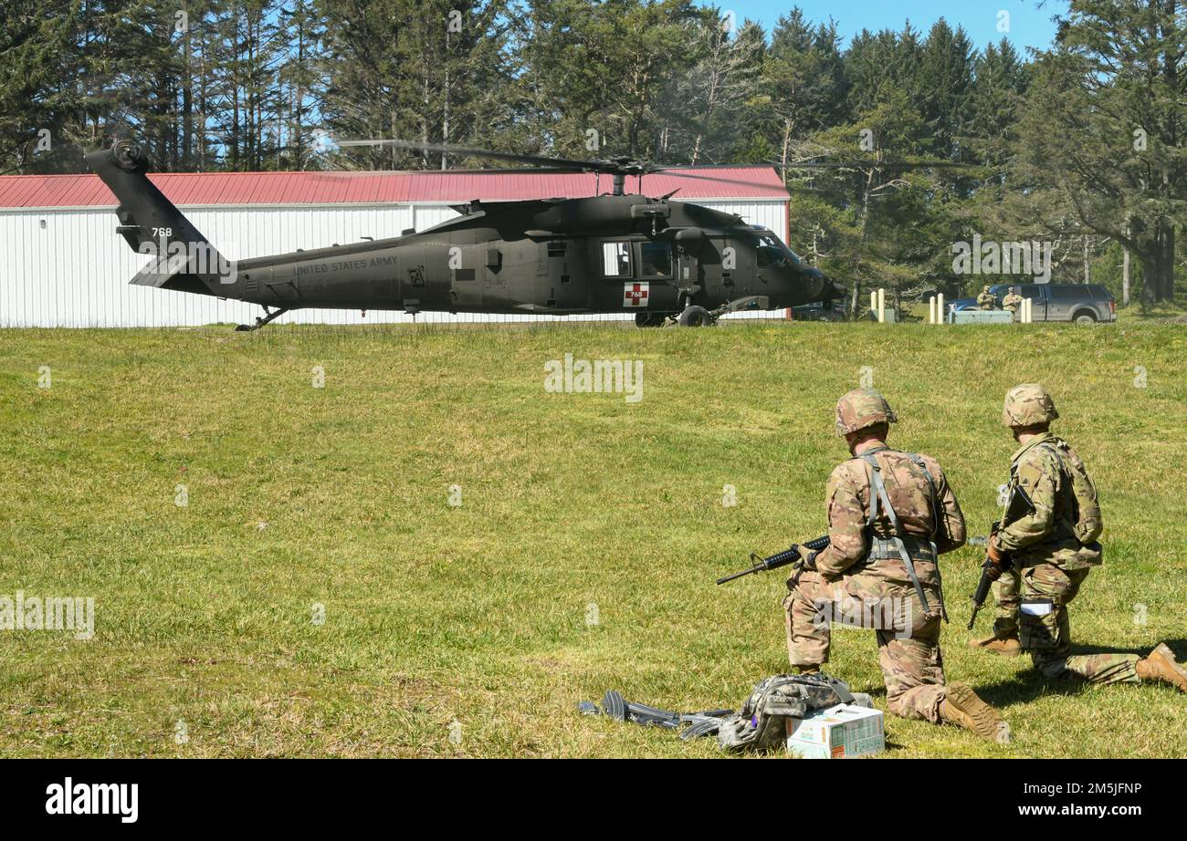 Oregon Army National Guard Soldiers wait to move toward a UH-60 Black hawk helicopter landing ...