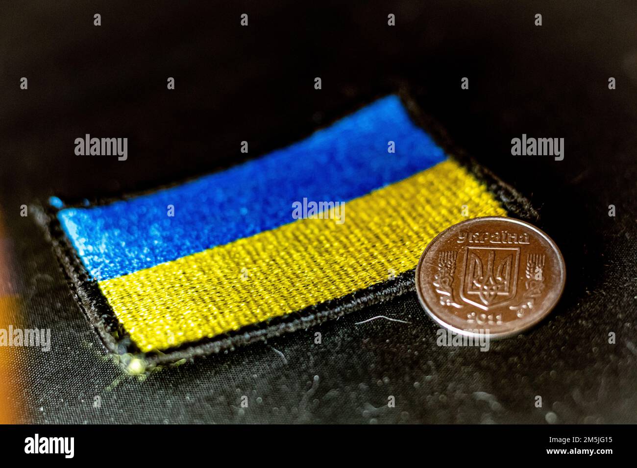 The Ukrainian flag badge for military outfit and a Ukrainian coin Stock ...