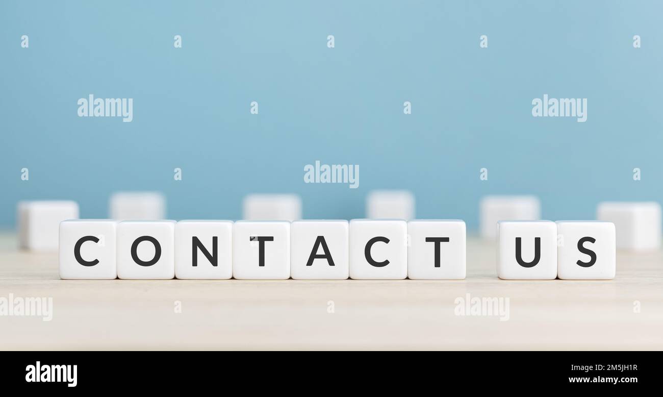 Contact us message on cube blocks on wood table. Copy space. Blue ...