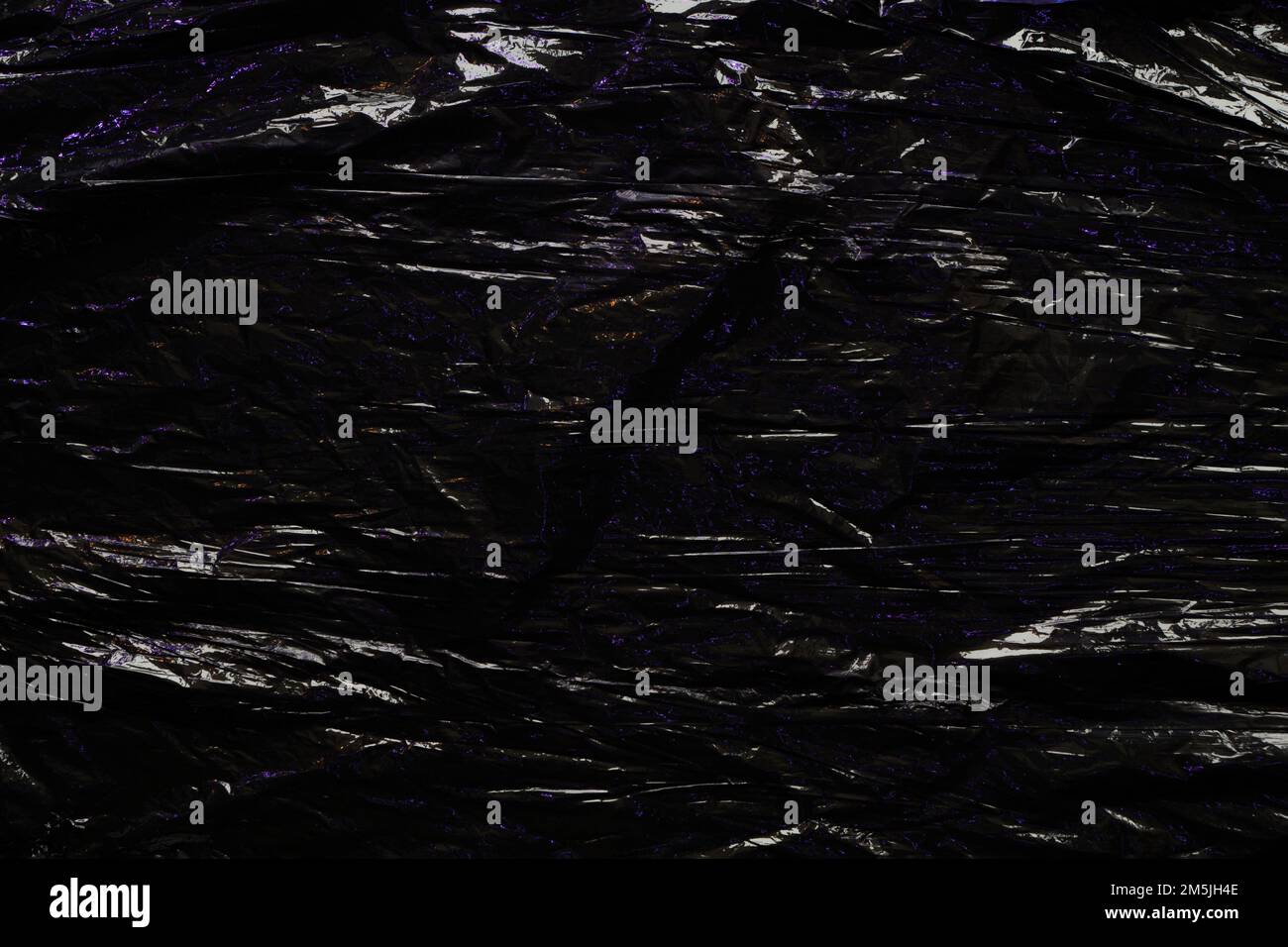 Black color plastic wrap background. Dark crumpled wrinkled plastic ...