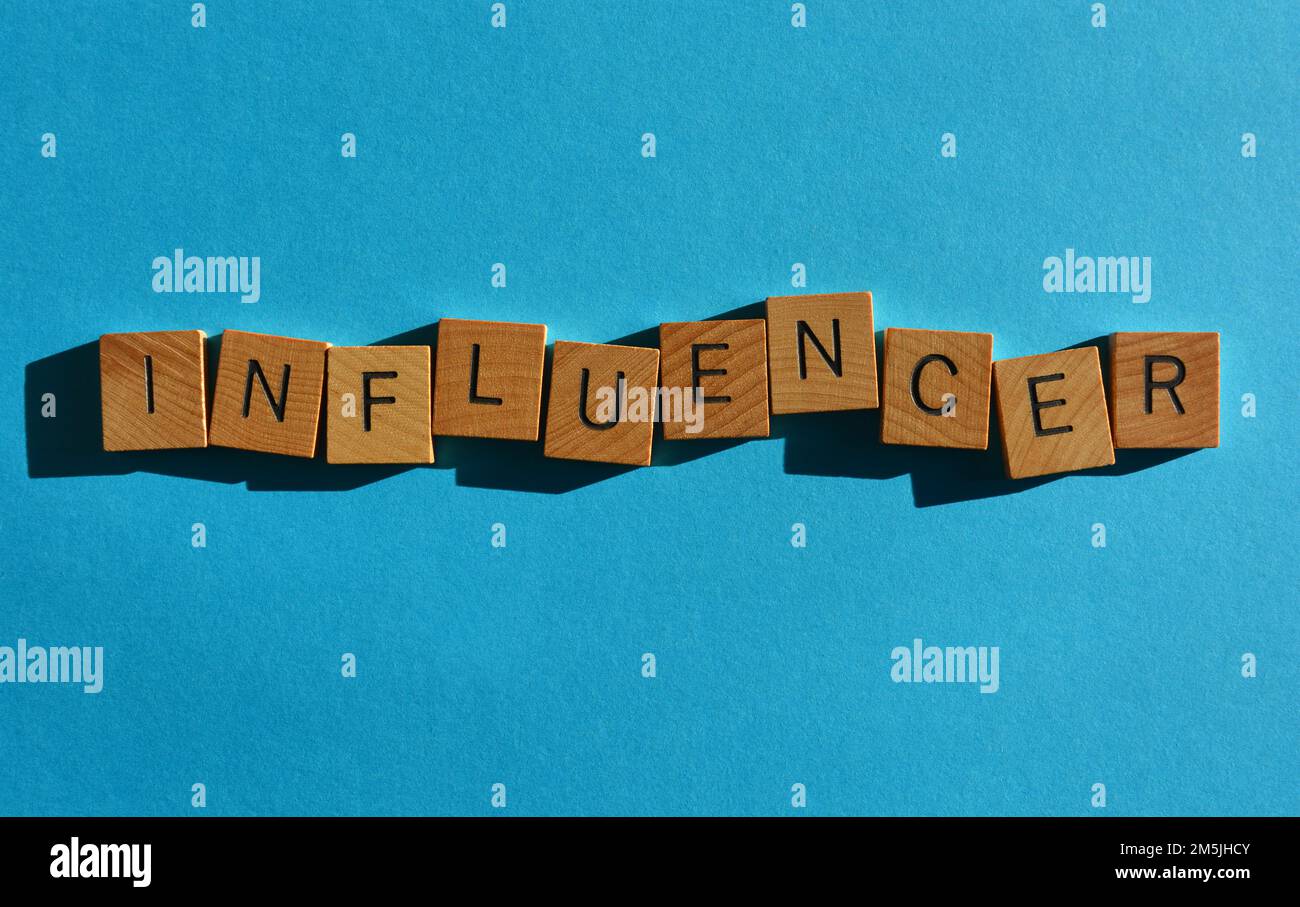 Influencer, word in wooden alphabet etters isolated on blue background ...