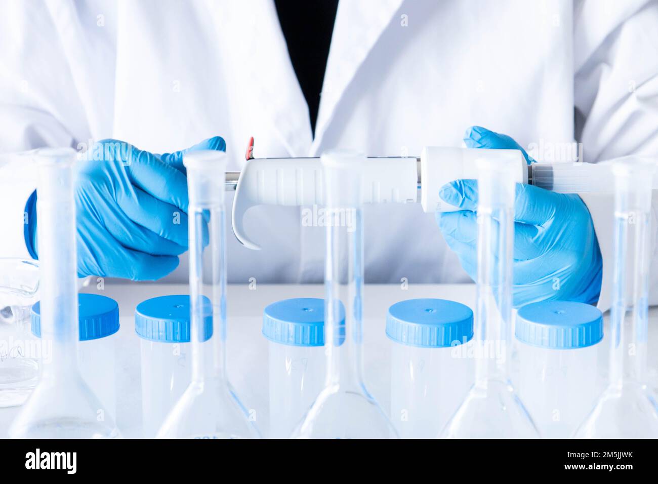 Left handed female scientist preparing a pipette with blue gloves and ...