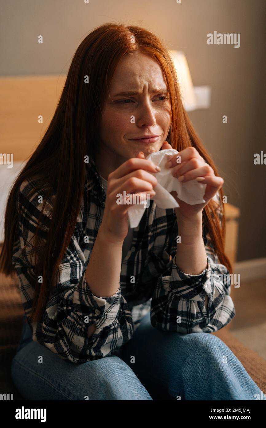 Vertical portrait of unhappy woman crying and wiping tears with ...