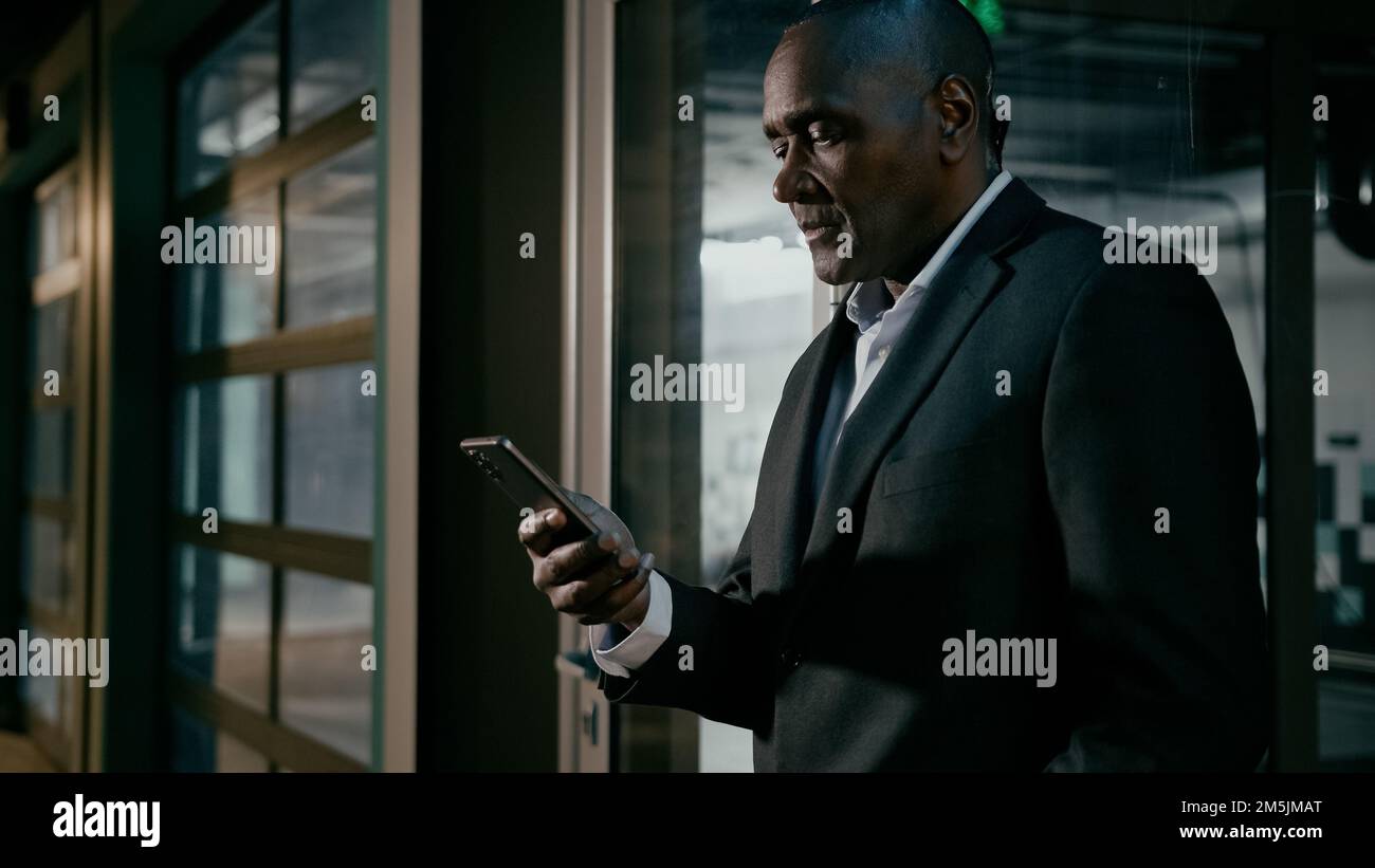 Serious focused businessman holding mobile phone chatting on internet ...