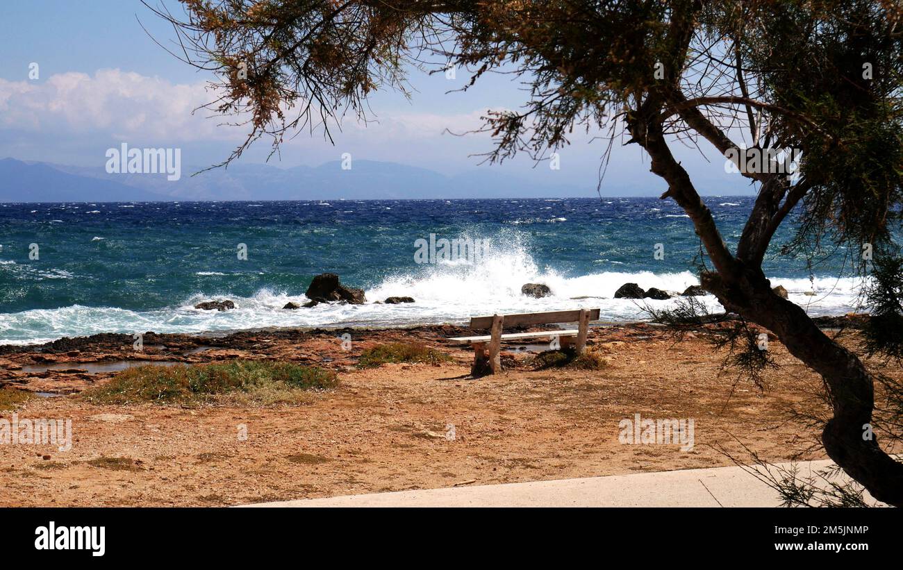 Bench on a rocky beach, waves Stock Photo - Alamy