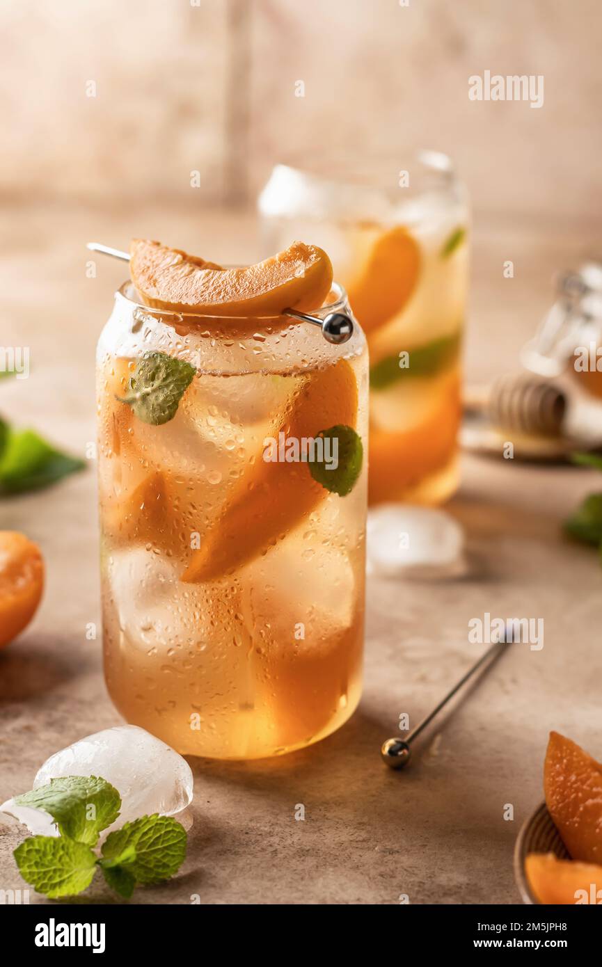 Fresh apricot cocktail, fizz or ice tea with mint and garnish. Pink ...