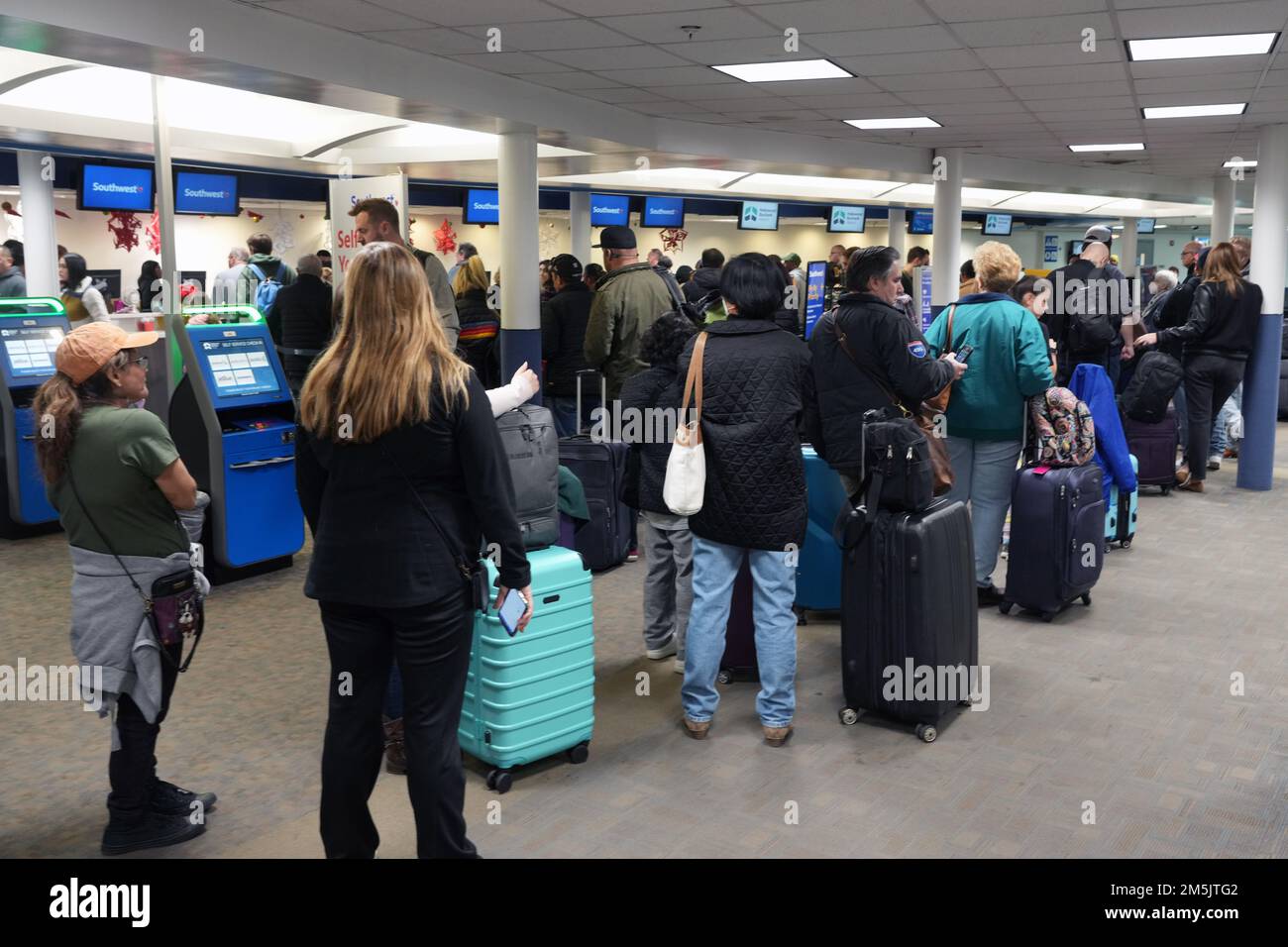 Passengers wait in line to check in luggage at the Southwest Airlines ticket counter at the ...