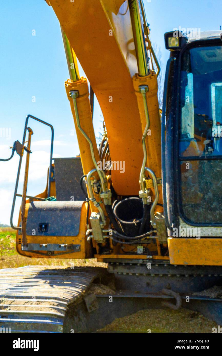 Yellow large excavator on the dike and forest in Loxstedt Cuxhaven ...