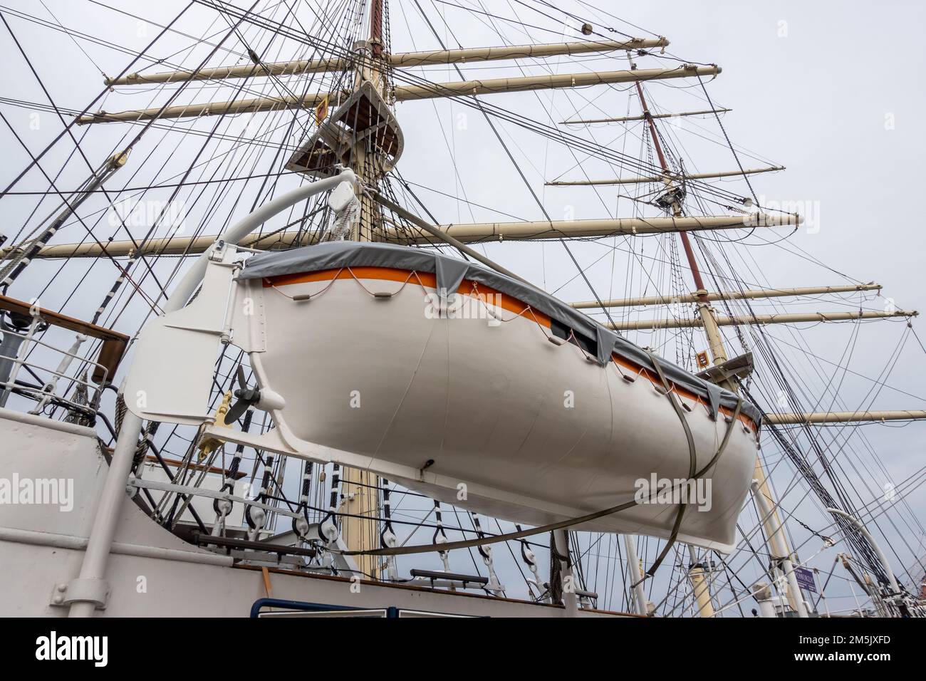 A white lifeboat on the side of a sea sailing ship. Life-saving ...