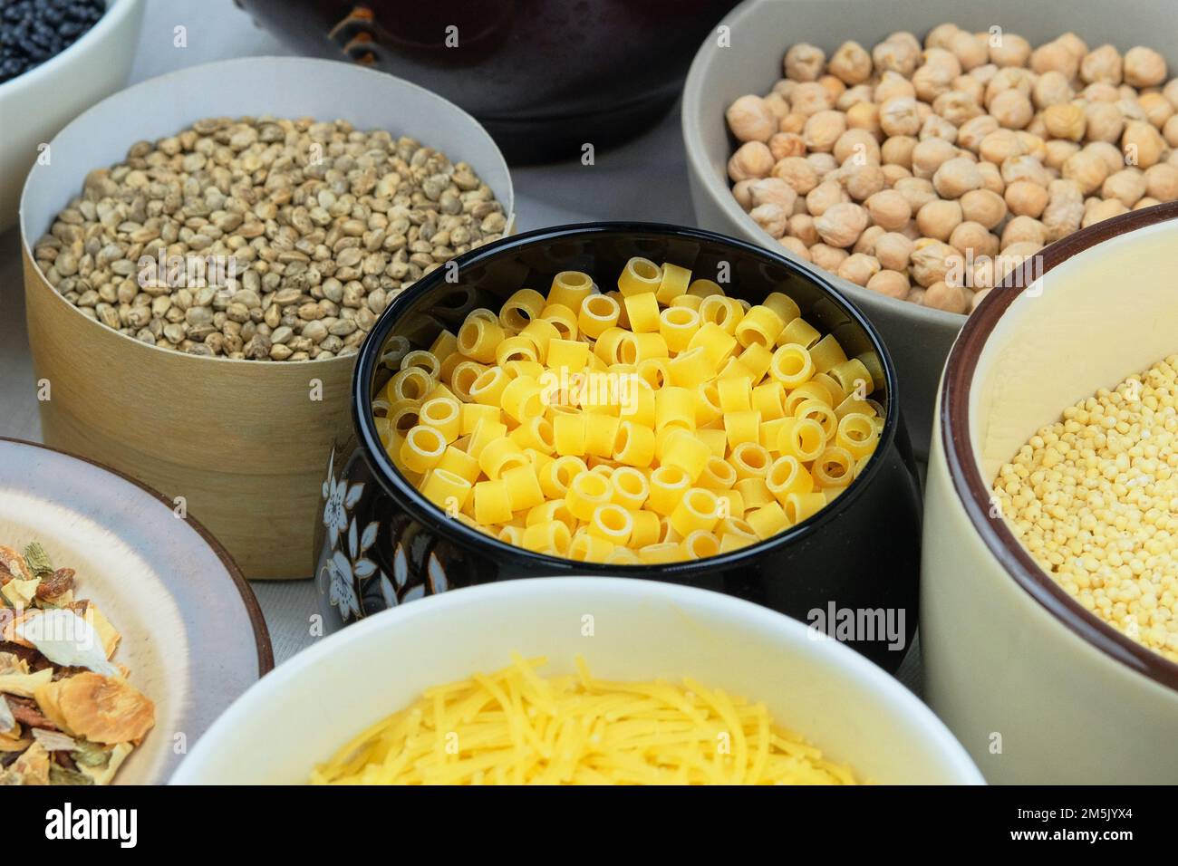 Yellow pasta in bowl on a straw background. Vegetarian organic product ...