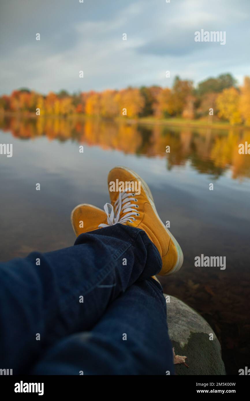 A vertical shot of a person extending their legs while admiring the ...