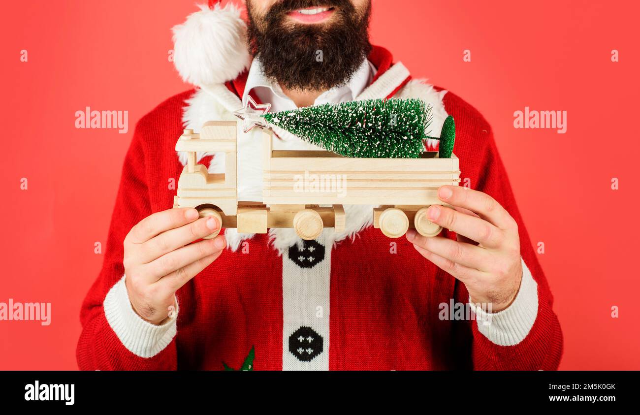 Santa man with Christmas tree on wooden toy truck car. Merry Christmas ...