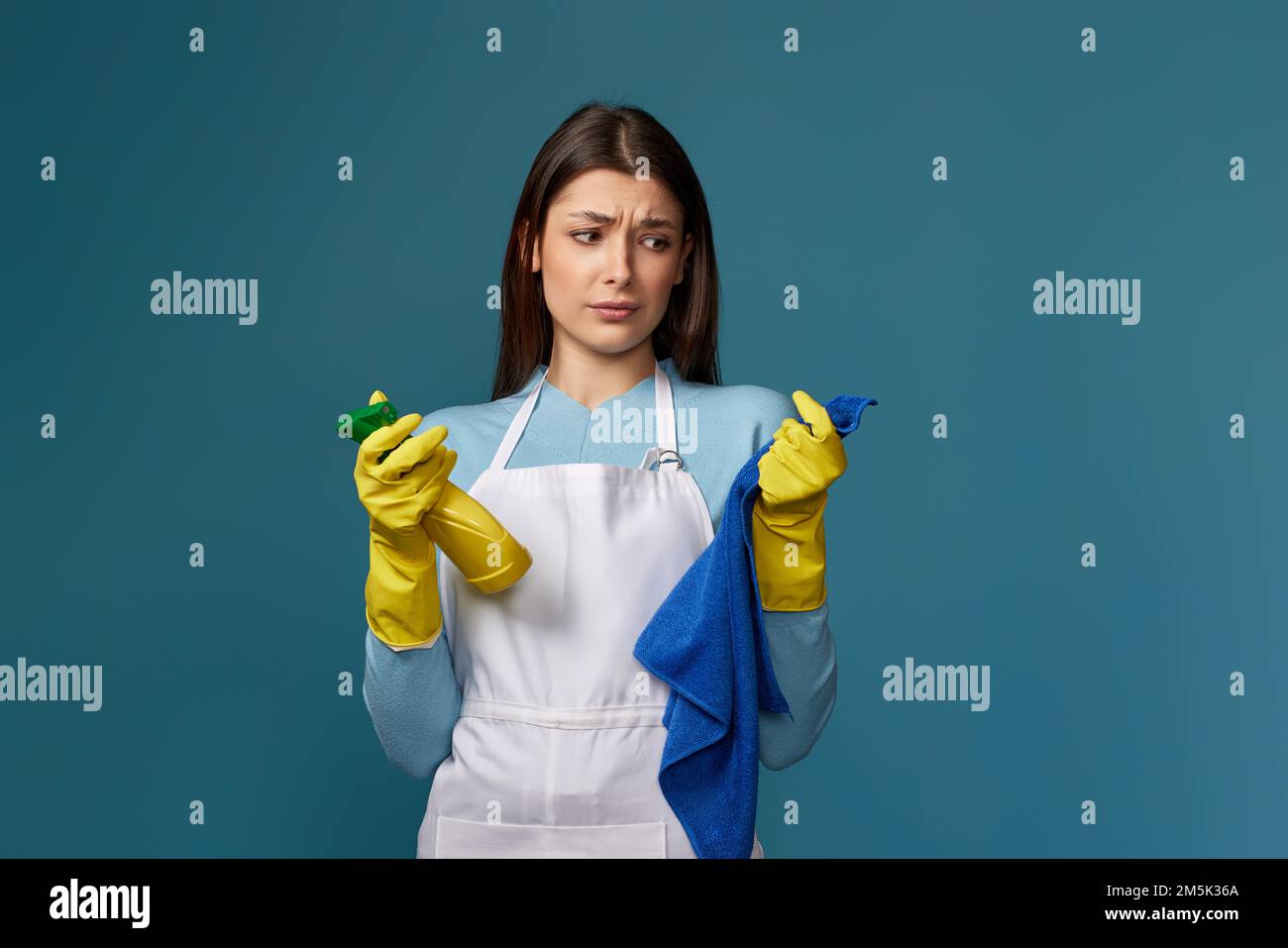 frowning woman cleaner apron with cleaning rag and detergent sprayer ...