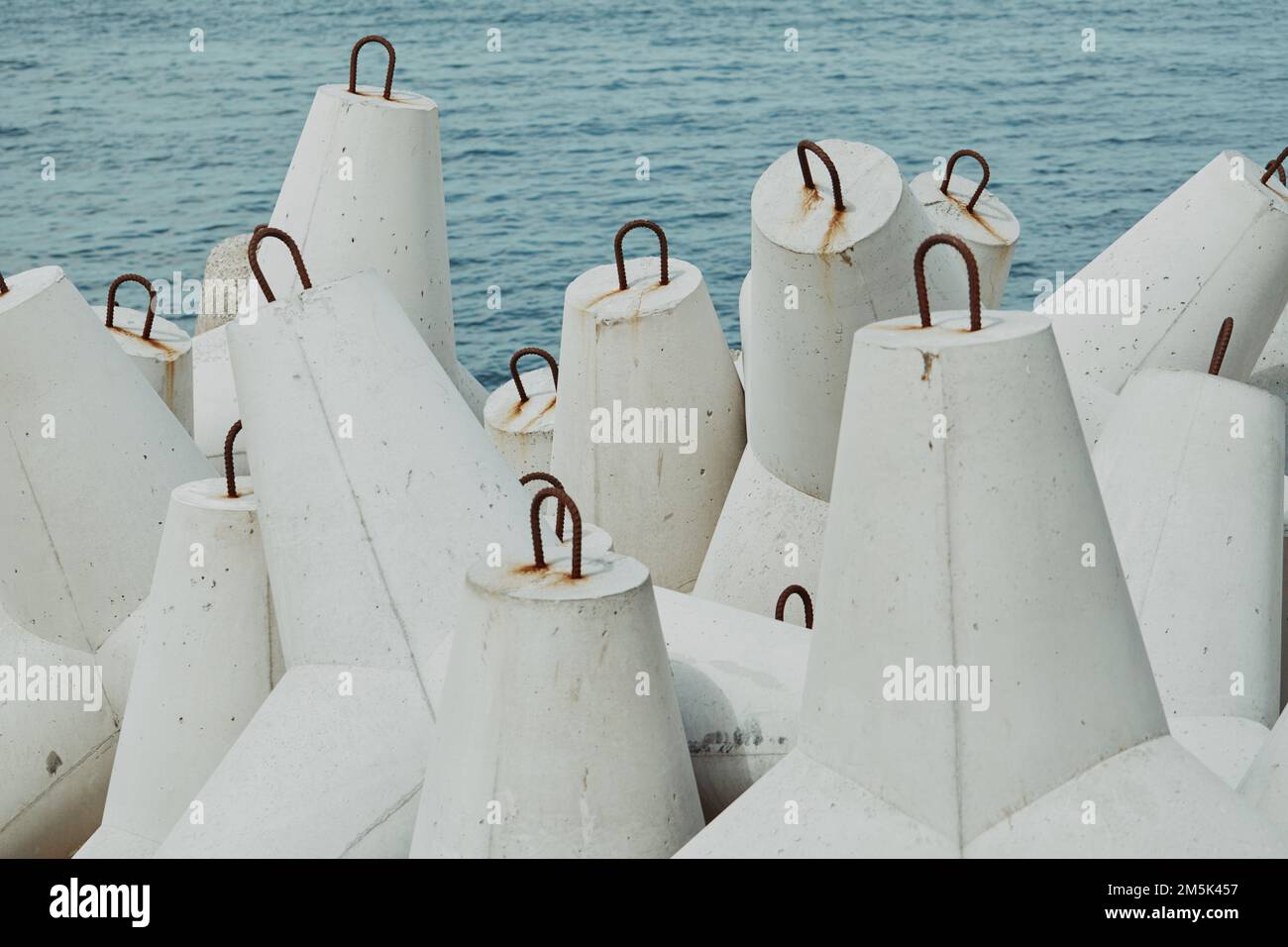 A closeup shot of the pile of white marine concrete tetrapods near the ...