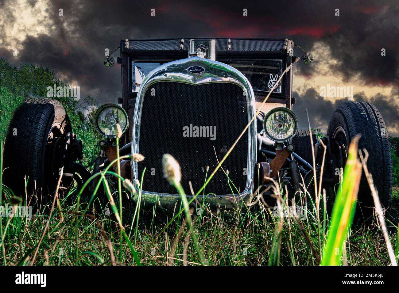 A black rat rod in a field under the stormy sky in Orillia, Ontario ...