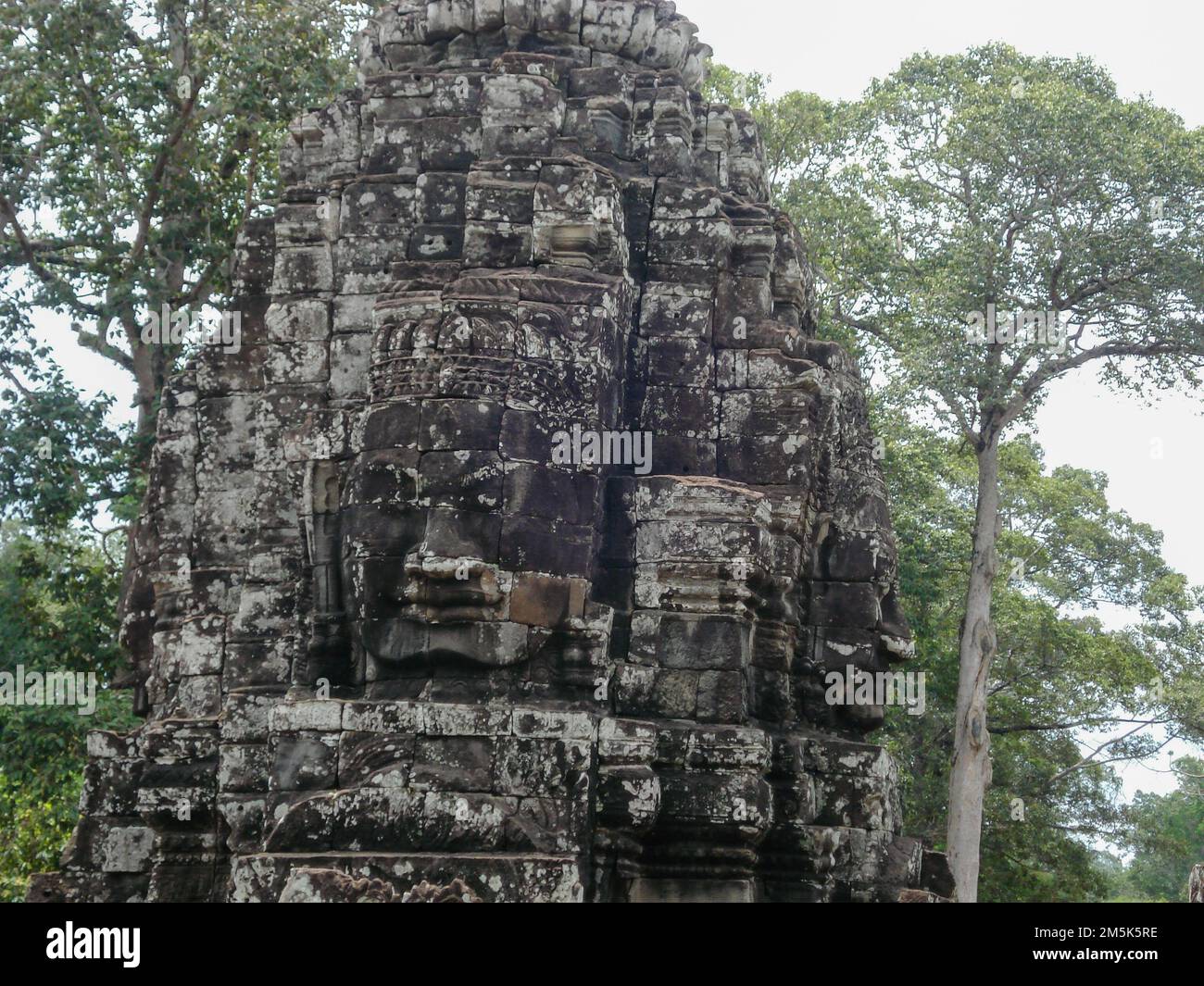 An image of a stone statue in front of trees in Angkor Wat, Cambodia ...