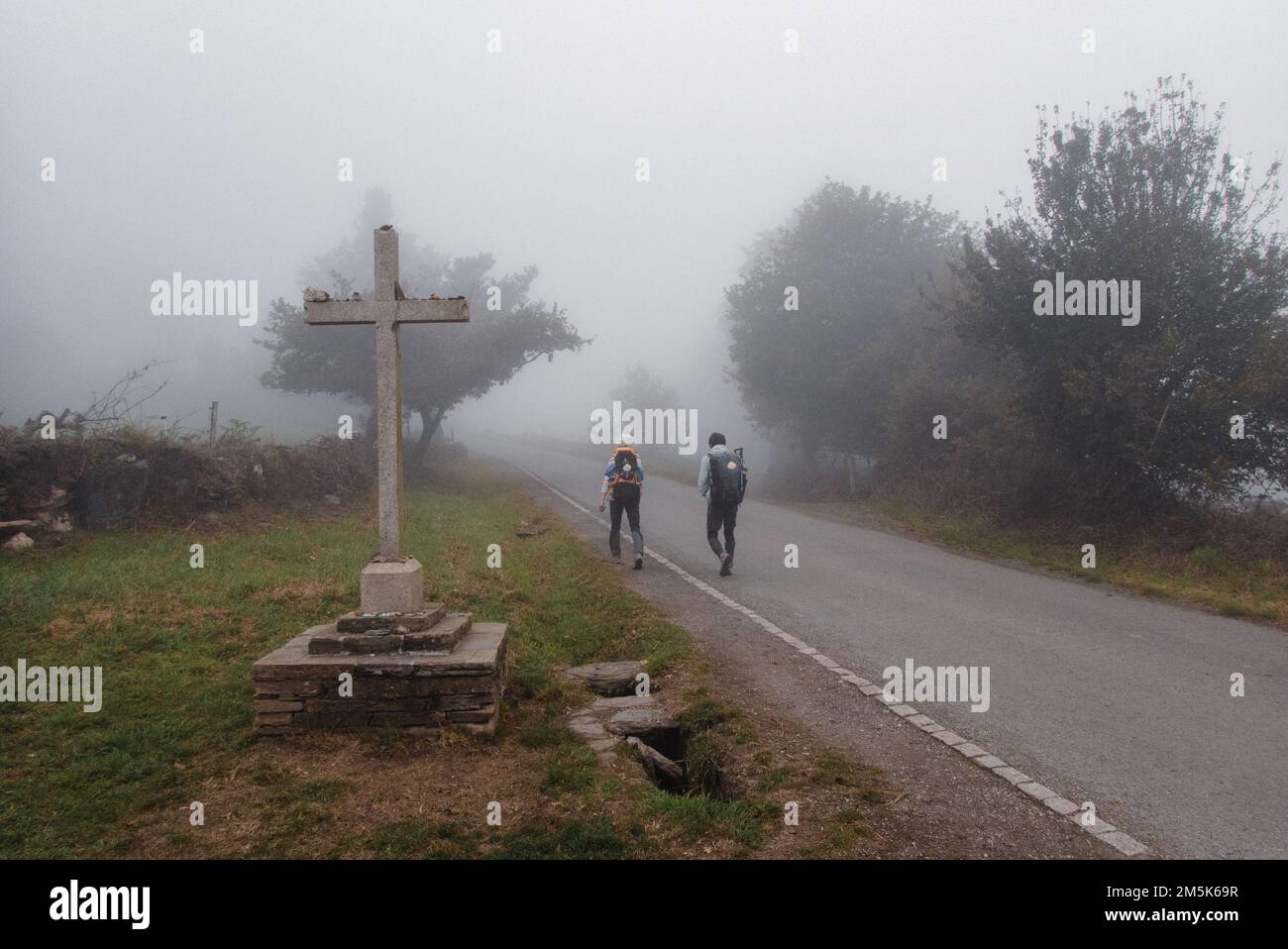 Two pilgrims on a misty morning on the Way of St. James en route to ...