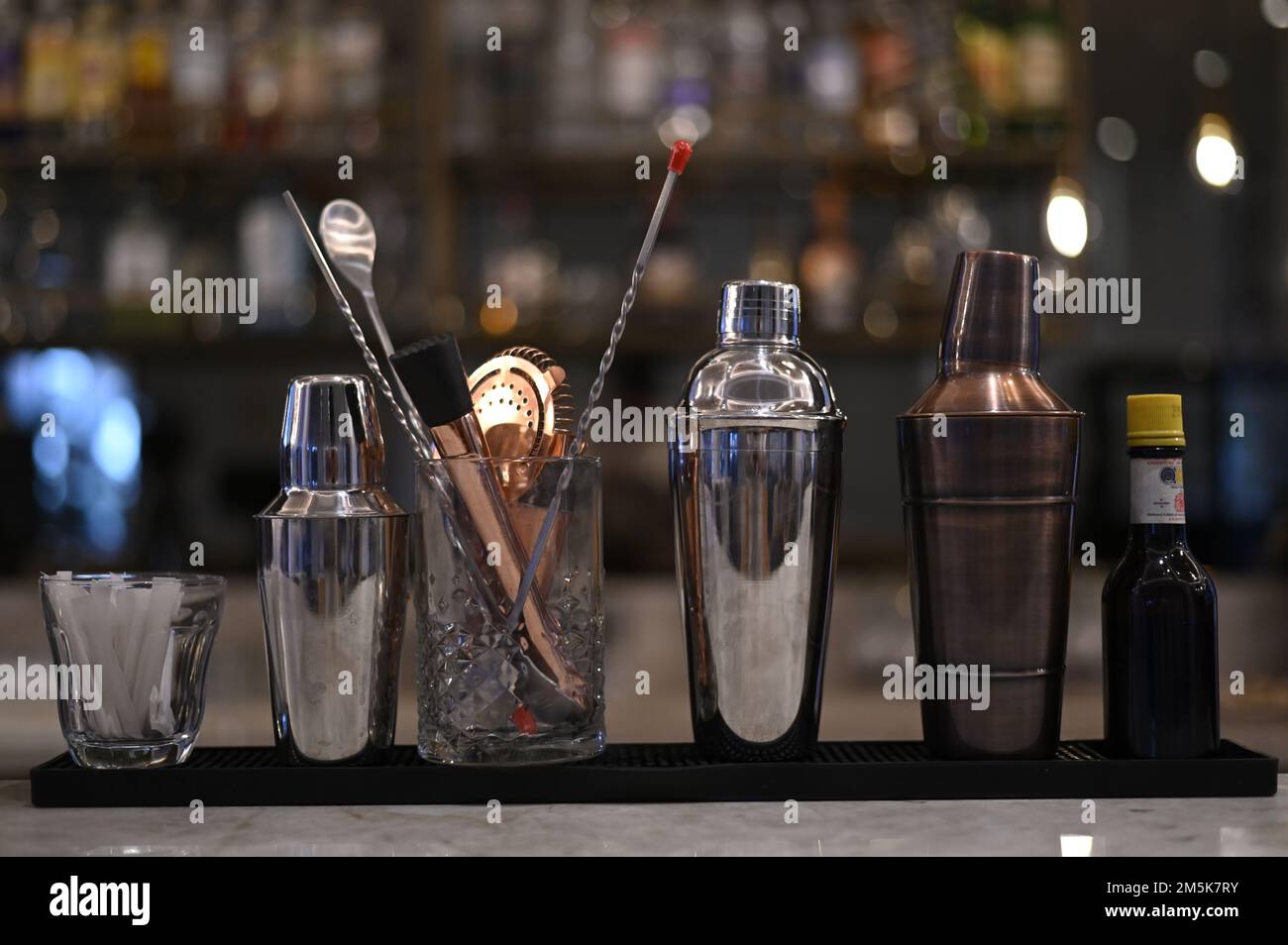 A closeup of the set of bar accessories for making cocktails lined up ...