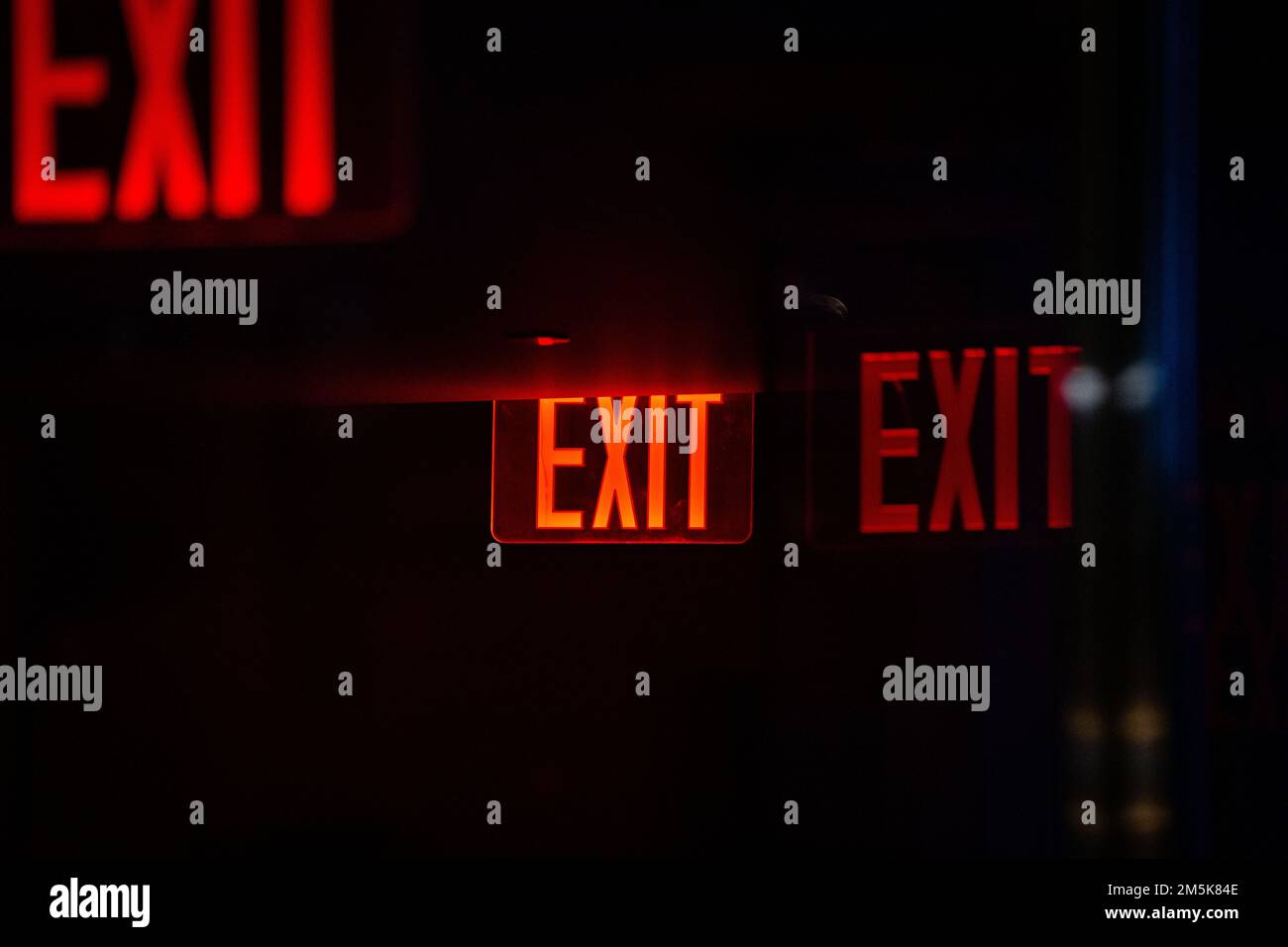 The Exit sign on a black surface and its reflection on the windows ...