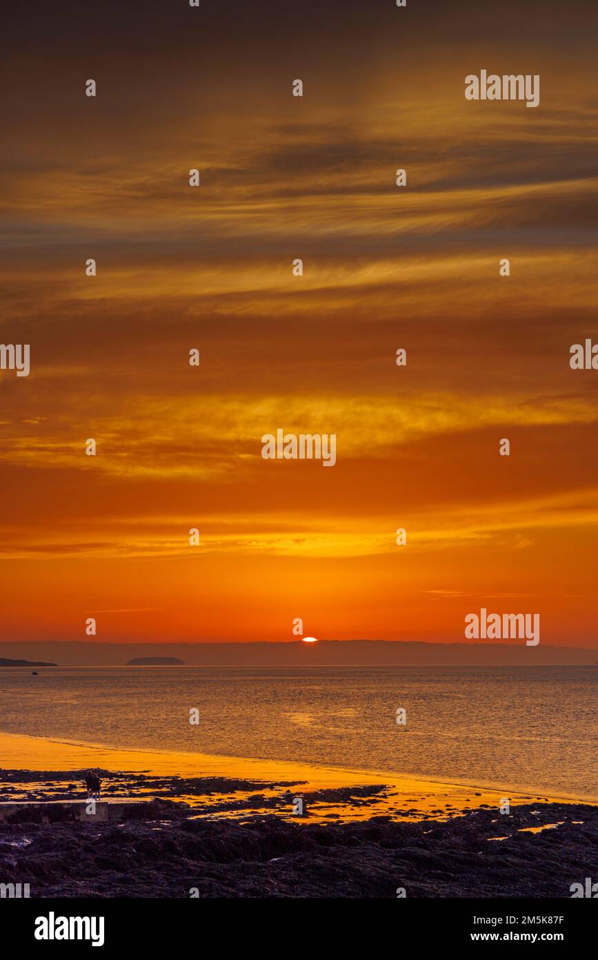 Sun setting over the horizon Stock Photo - Alamy
