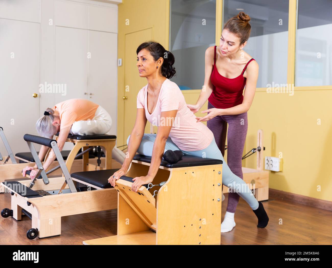 Latin american woman trains on a combined chair with a female ...