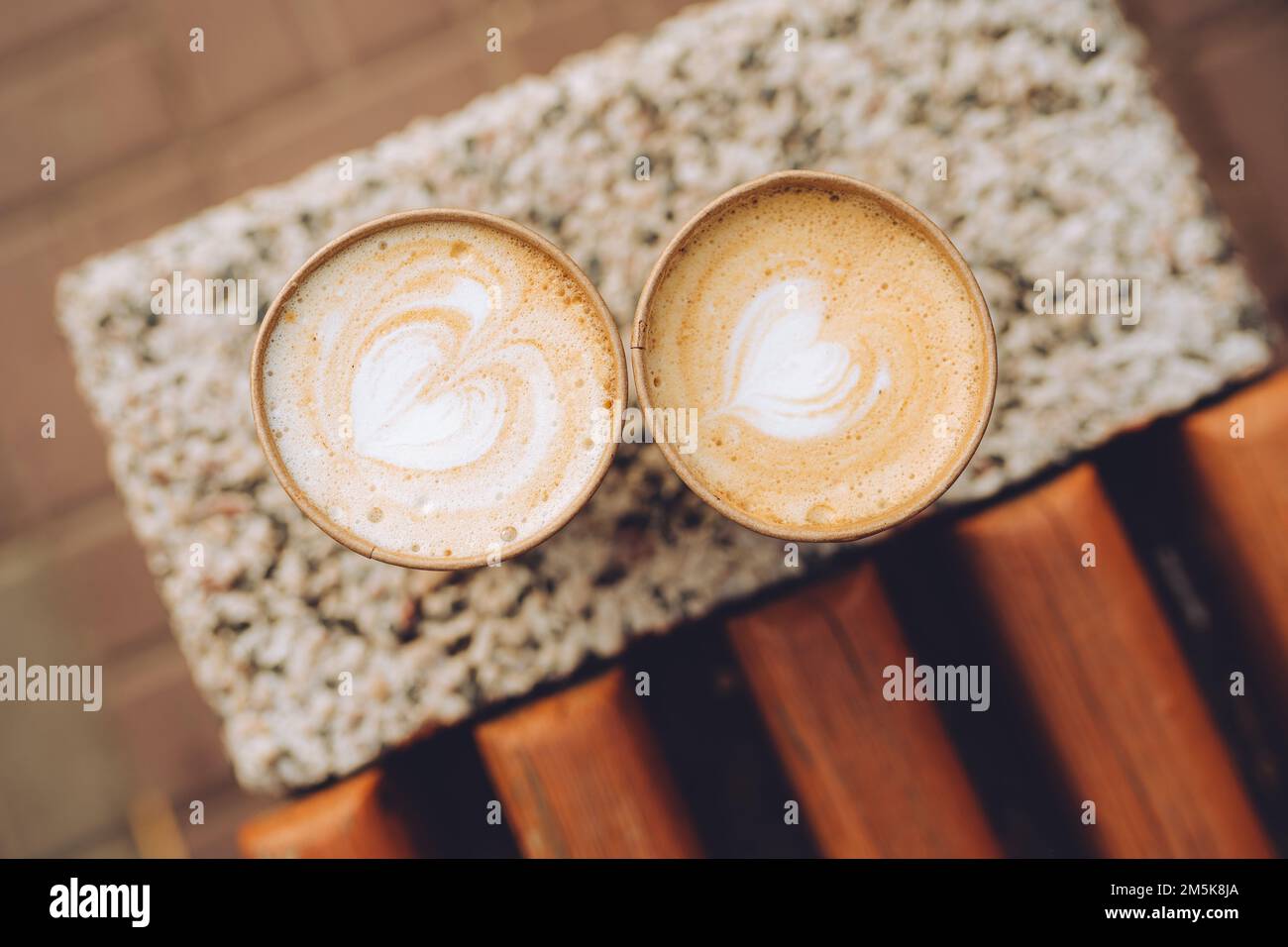 Two paper cups of cappuccino with latte art. Beautiful foam, coffee to ...
