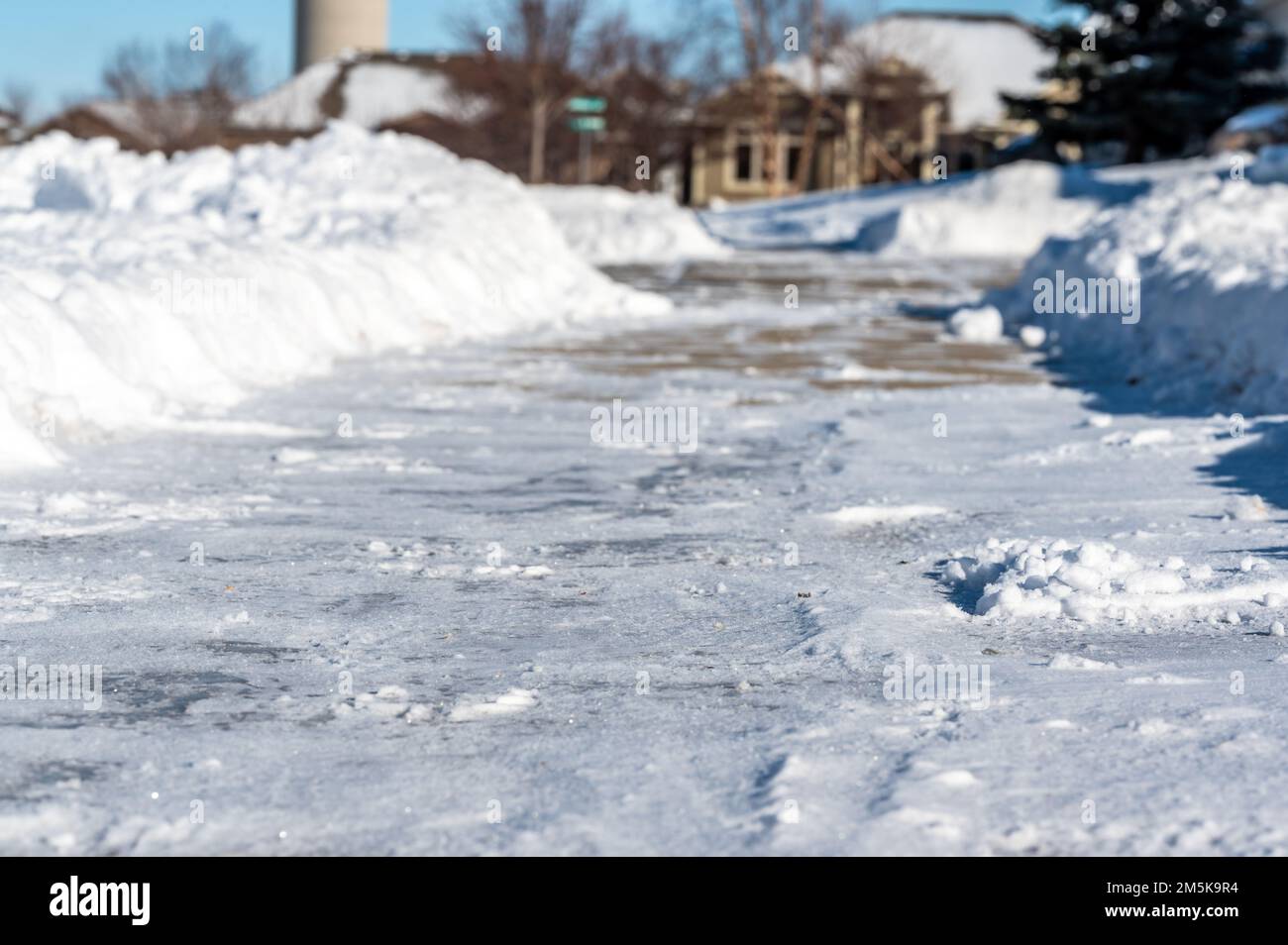 Selective focus ground level view of snow blown sidewalk section with ...