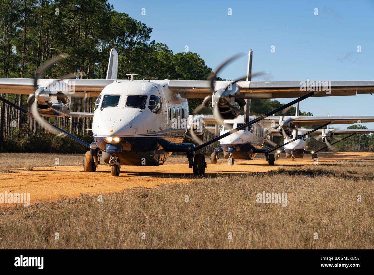 Three C-145A Combat Coyote aircraft sit parked on a dirt runway on the ...