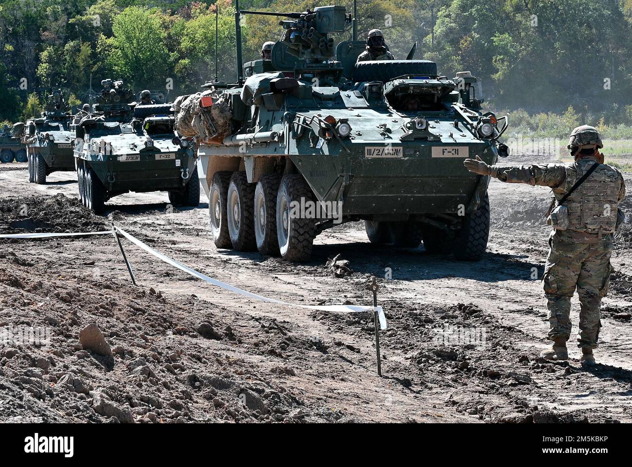 Three M1126 Stryker Combat Vehicles prepares to cross an improved ...