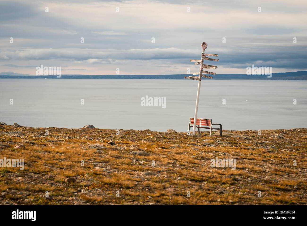 Park bench and distance sign at a viewpoint in Pond Inlet overlooking ...