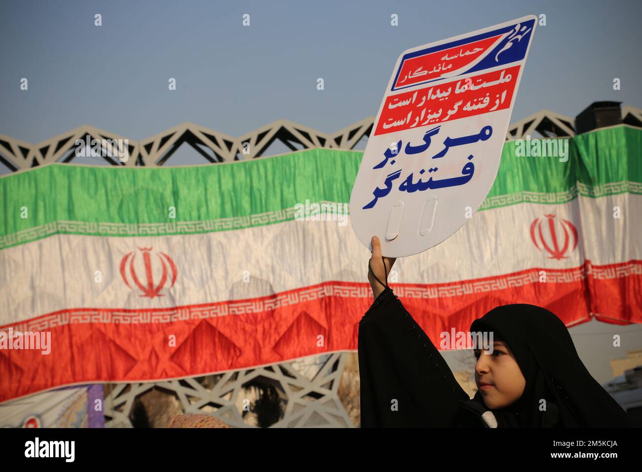 Tehran, Tehran, Iran. 29th Dec, 2022. A veiled woman carries a poster ...