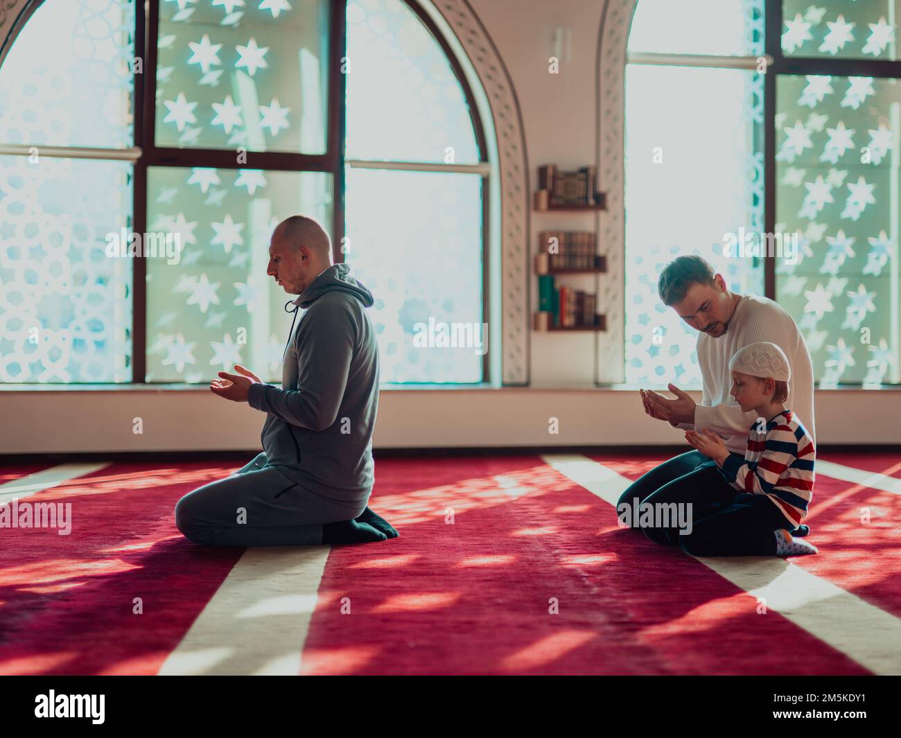 A group of Muslims in a modern mosque praying the Muslim prayer namaz ...