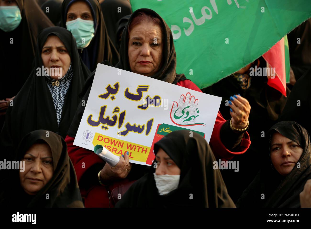 Tehran, Tehran, Iran. 29th Dec, 2022. A veiled woman carries a poster ...