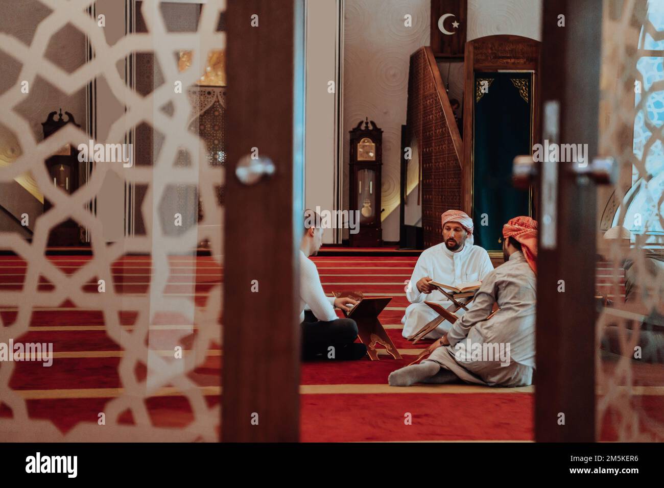 A group of Muslims reading the holy book of the Quran in a modern ...
