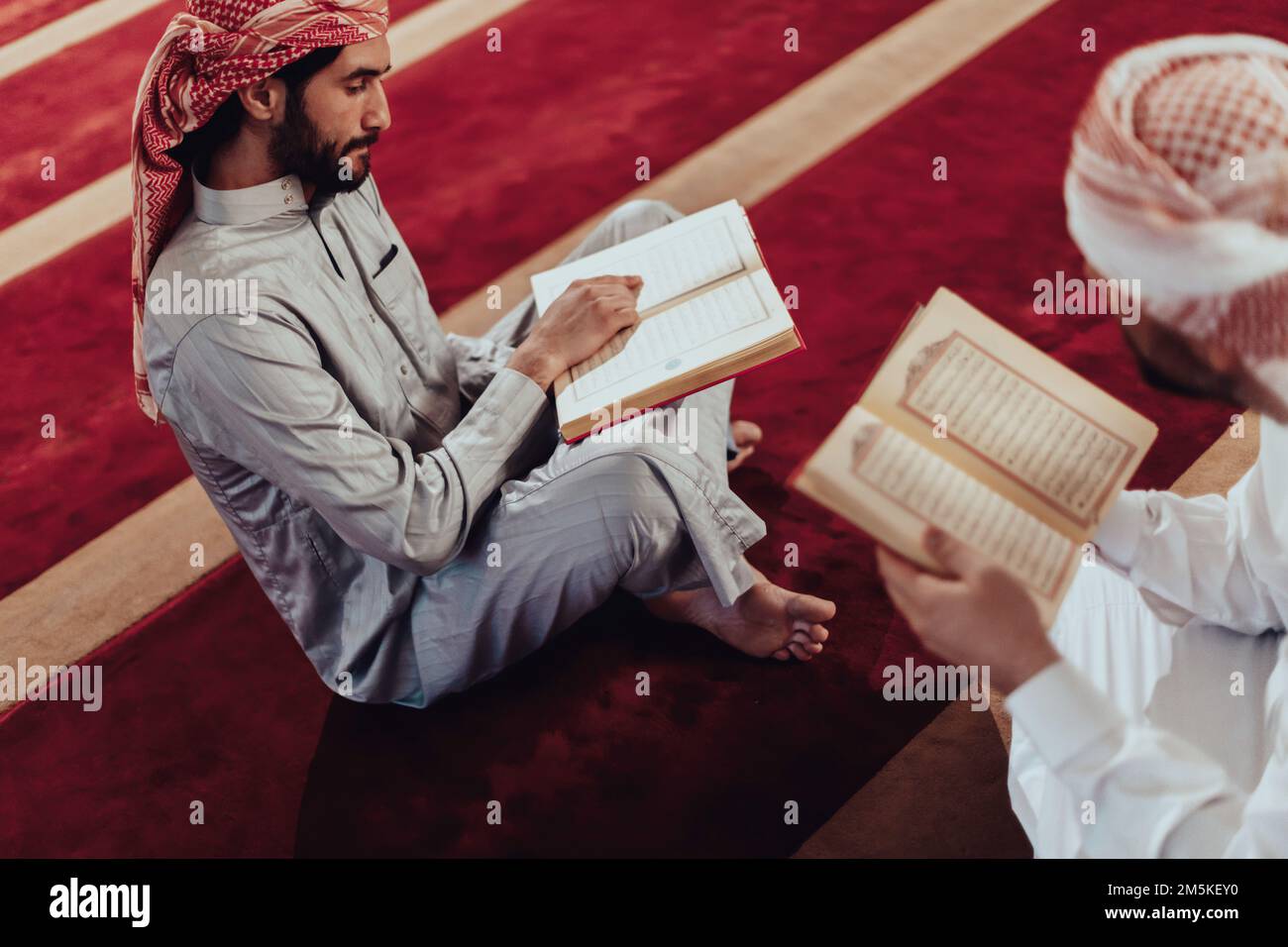 A group of Muslims reading the holy book of the Quran in a modern ...