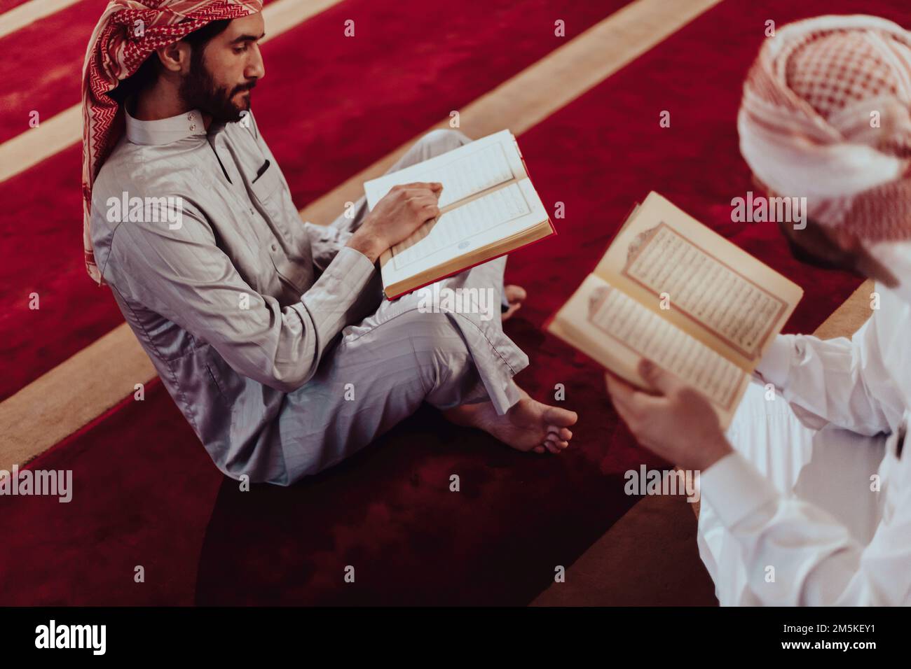 A group of Muslims reading the holy book of the Quran in a modern ...