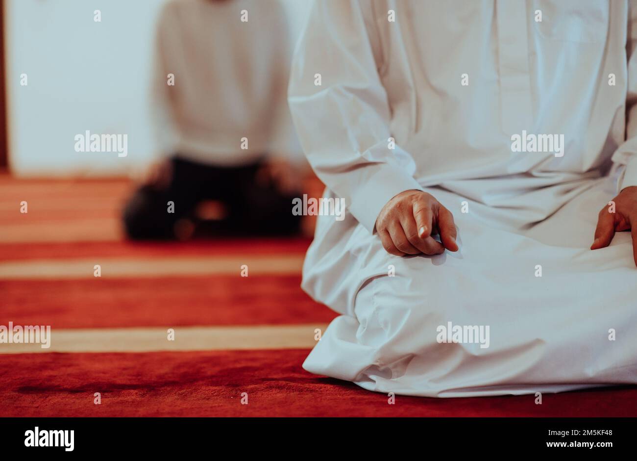A group of Muslims in a modern mosque praying the Muslim prayer namaz ...