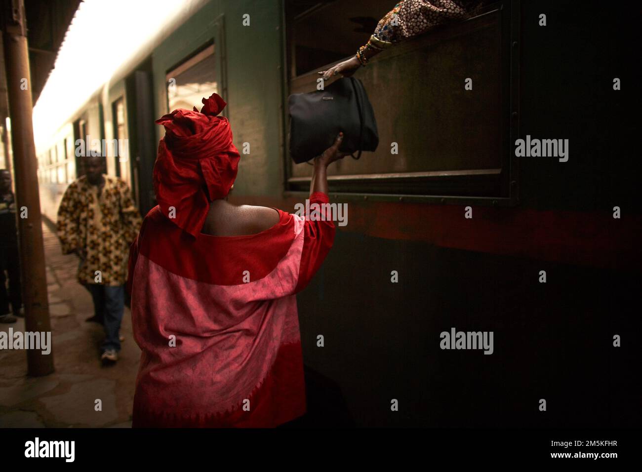 Woman say goodbye or hand luggage outside the train through the window ...