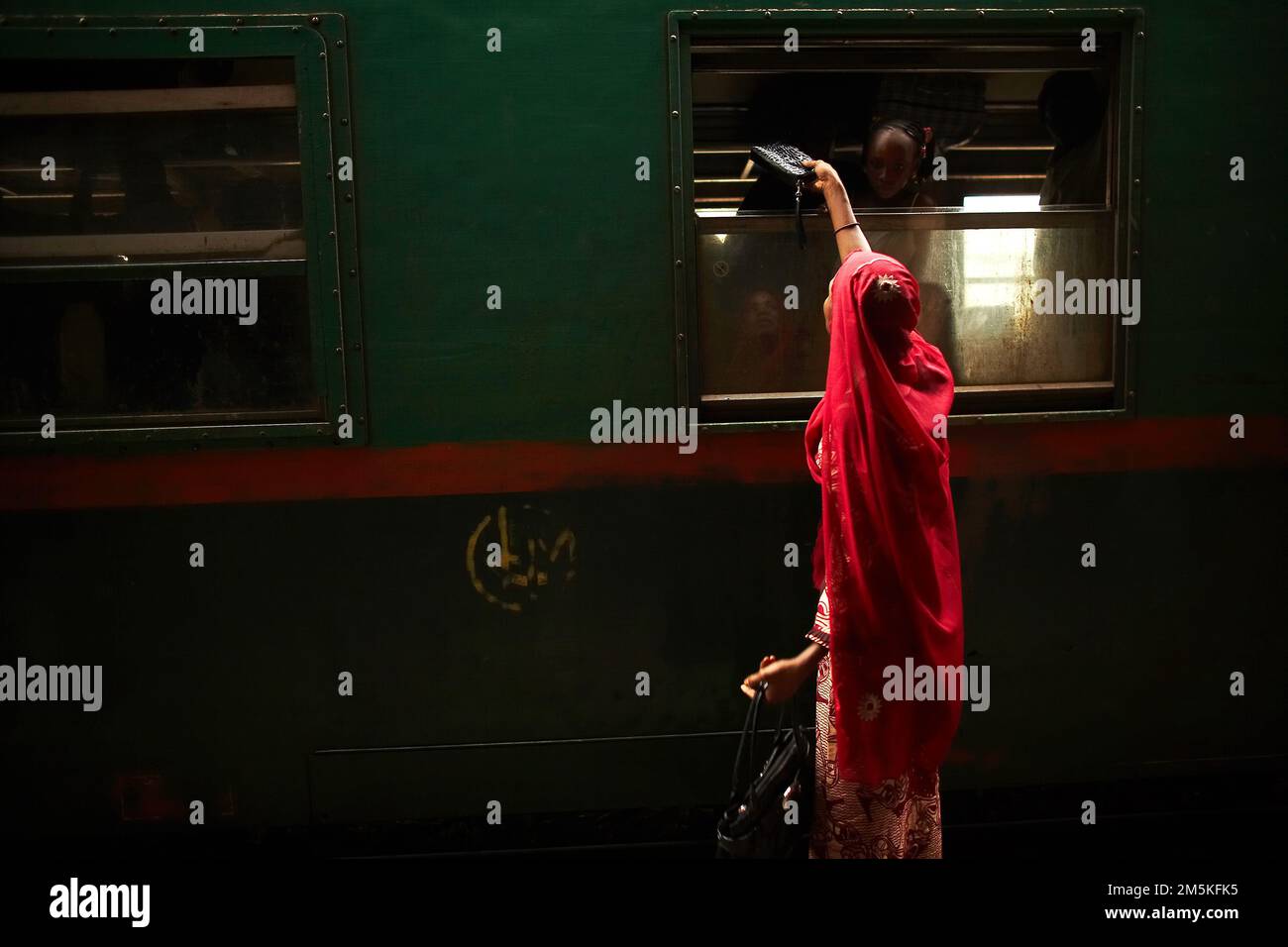 Woman say goodbye or hand luggage outside the train through the window ...