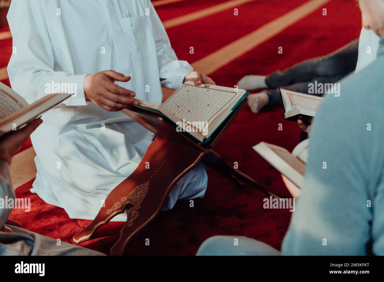 A group of Muslims reading the holy book of the Quran in a modern ...