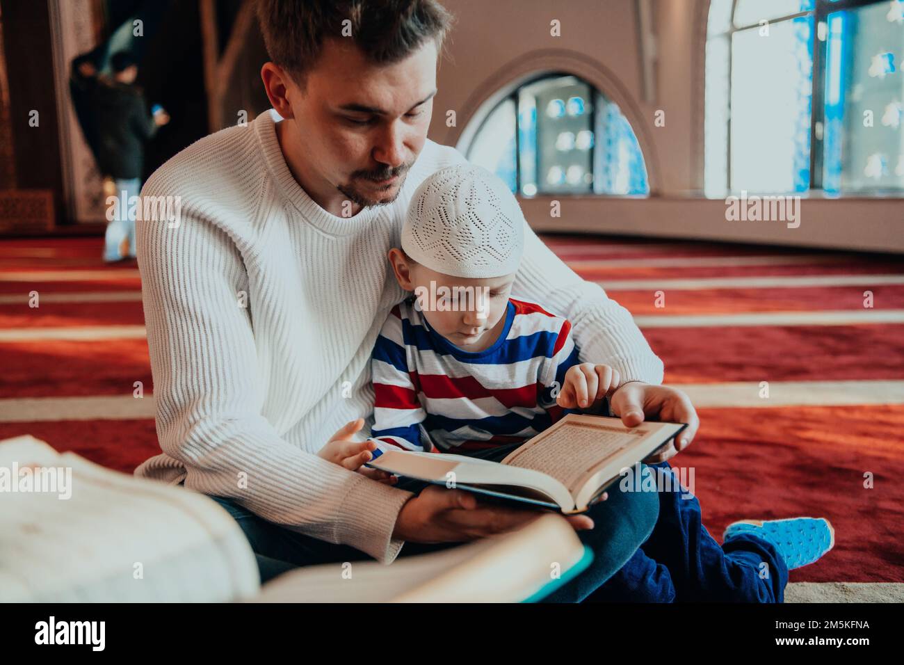 Muslim prayer father and son in mosque praying and reading holly book ...