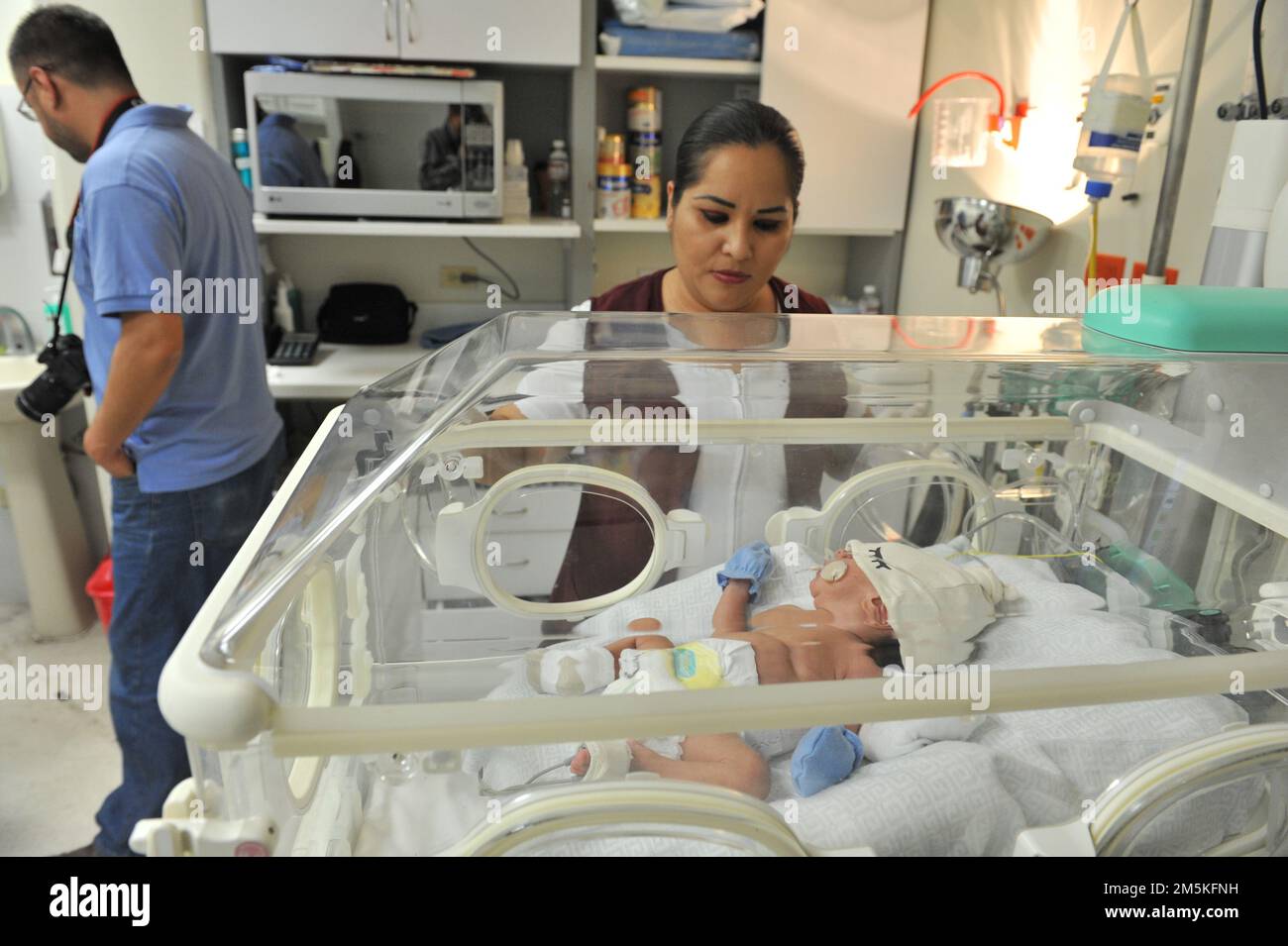 nurse with baby in nursery or intensive therapy or baby incubators ...