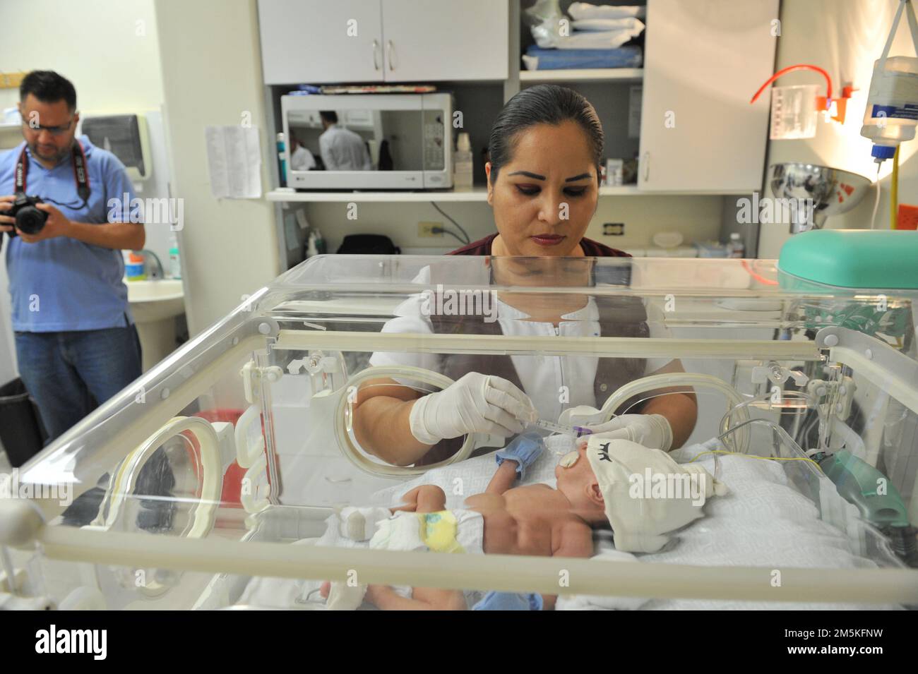 nurse with baby in nursery or intensive therapy or baby incubators ...