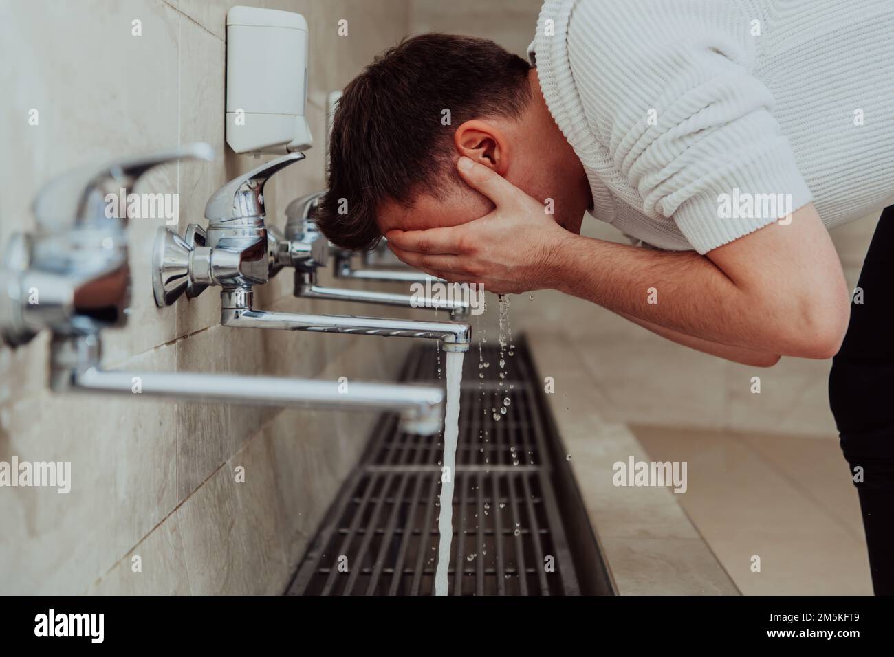 A Muslim performing ablution. Ritual religious cleansing of Muslims ...