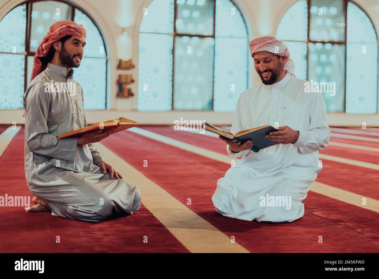 A group of Muslims reading the holy book of the Quran in a modern ...