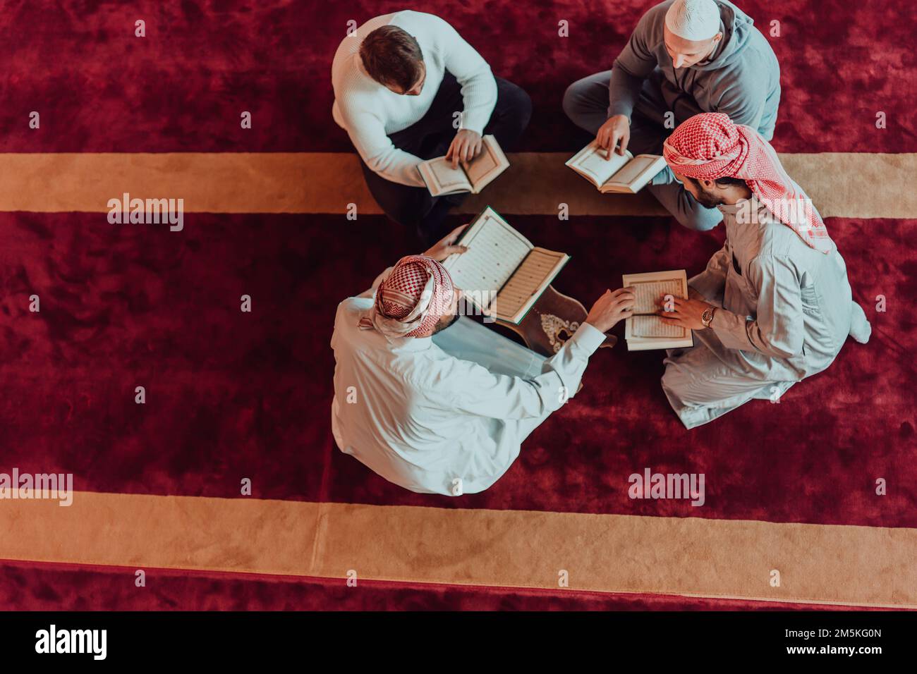 A group of Muslims reading the holy book of the Quran in a modern ...