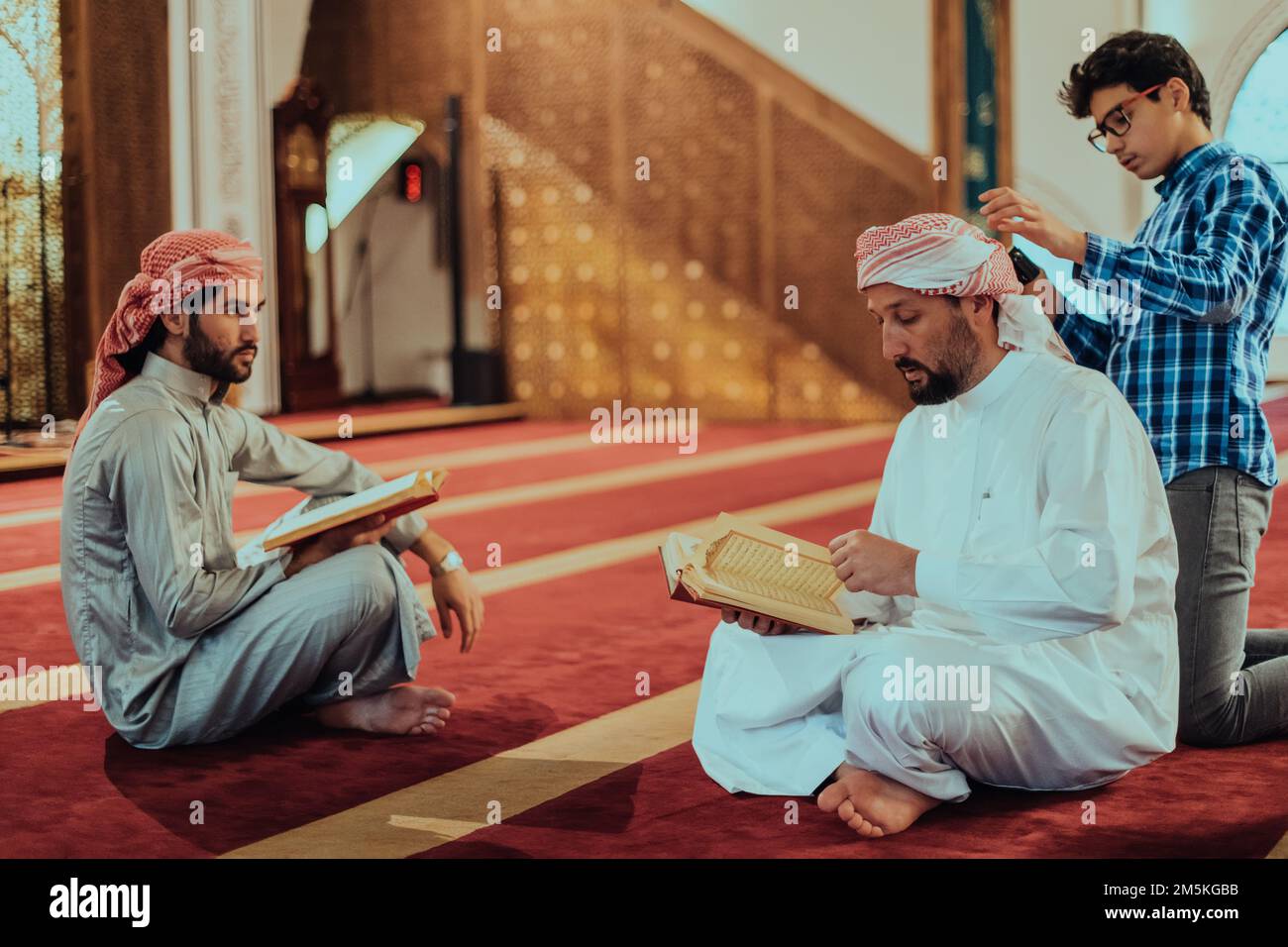 A group of Muslims reading the holy book of the Quran in a modern ...