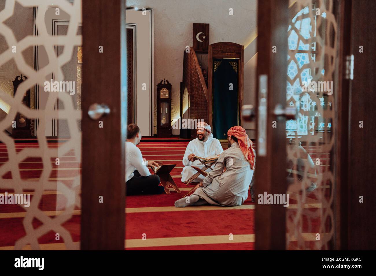A group of Muslims reading the holy book of the Quran in a modern ...