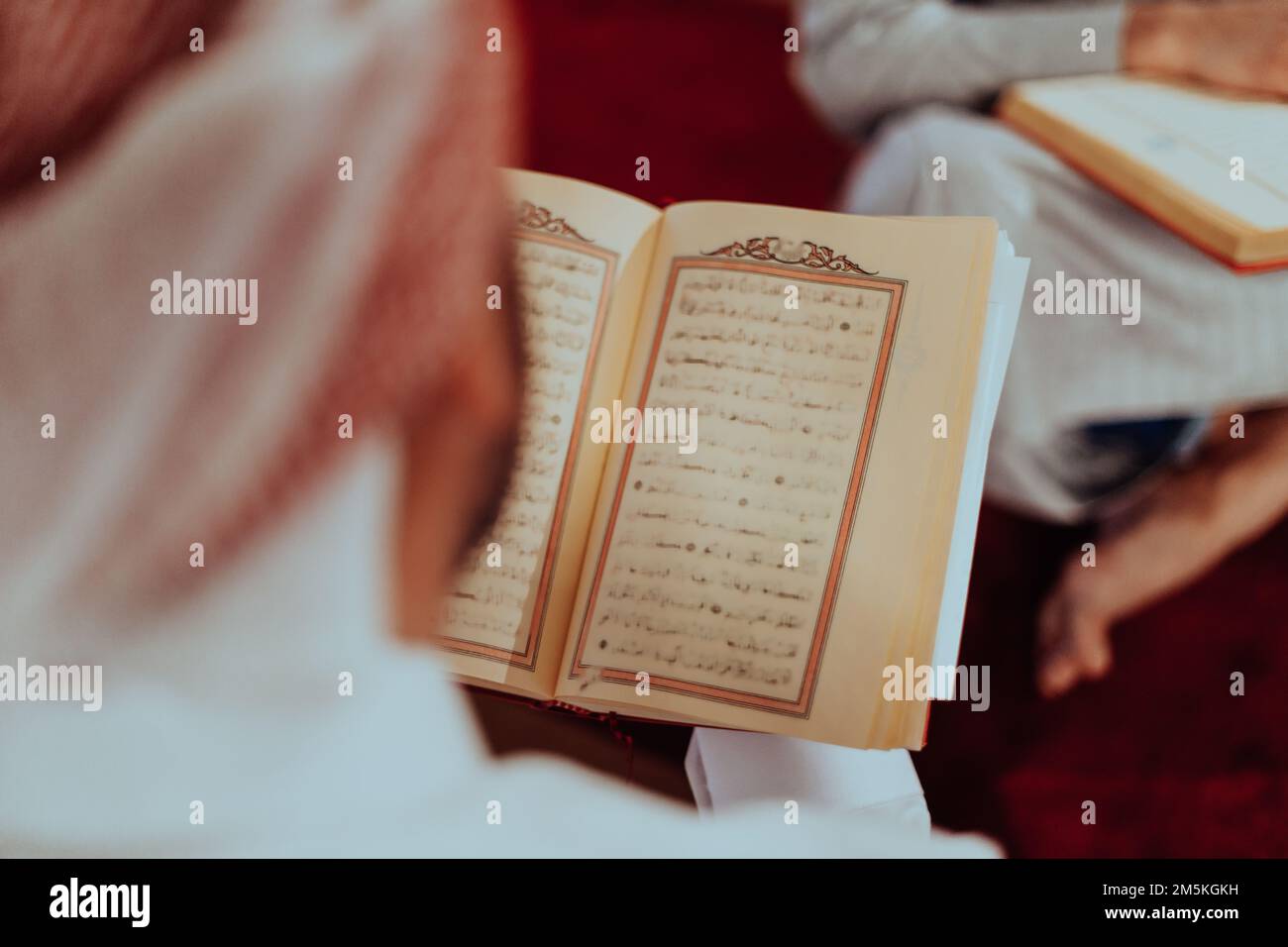 A group of Muslims reading the holy book of the Quran in a modern ...